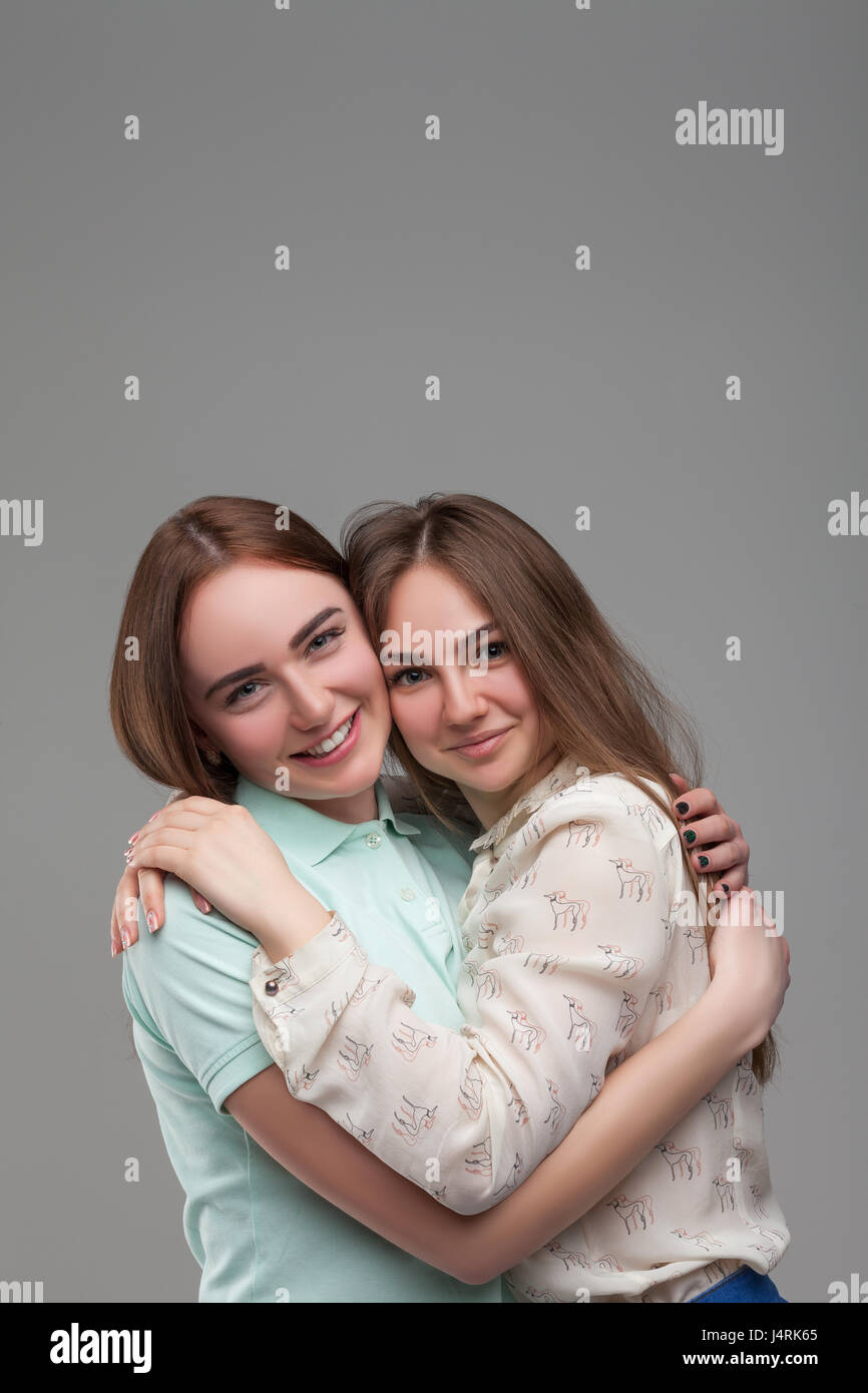Two happy girlfriends hugs together, studio photo shoot. Female ...