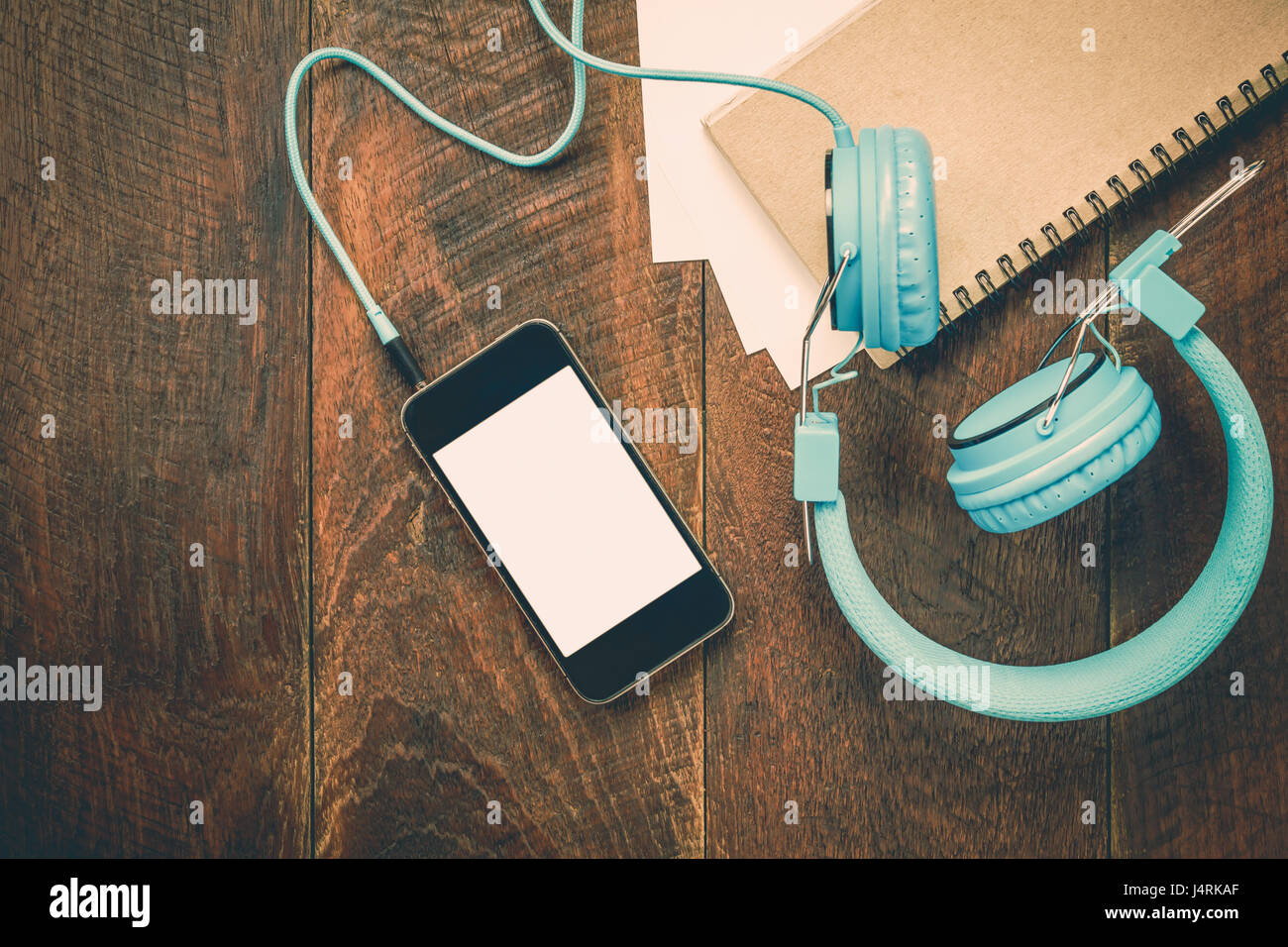 Top view note paper,headphones,smartphone,pencil,on wooden office desk ...