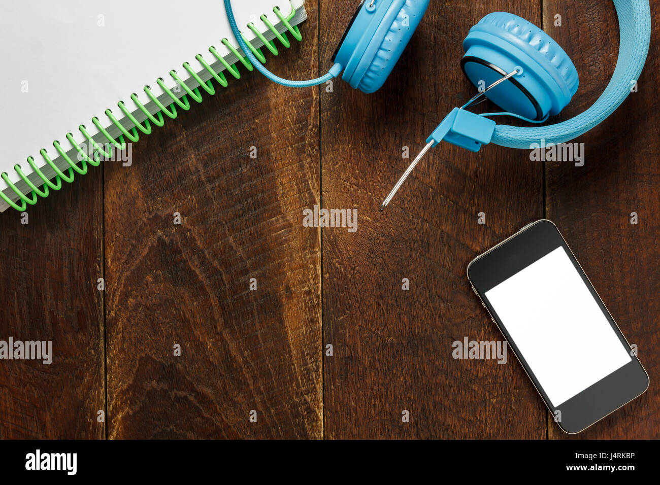 Top view note paper,headphones,smartphone,pencil,on wooden office desk ...