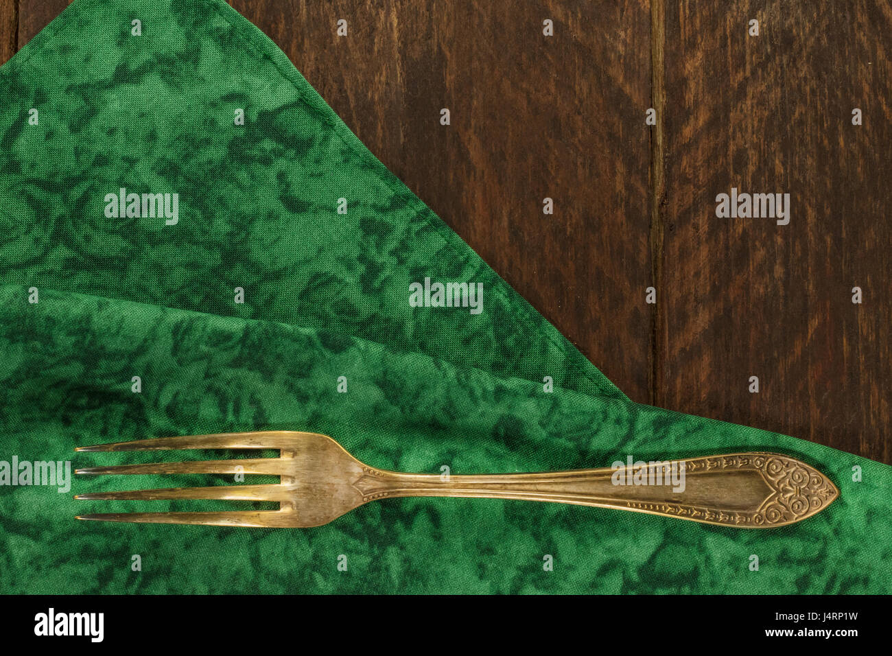 An overhead photo of a vintage fork on a dark wooden background texture ...