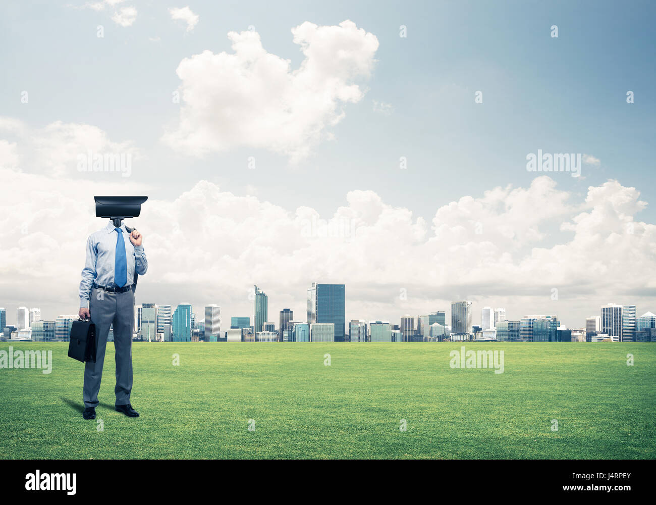 Camera headed man standing on green grass against modern citysca Stock ...