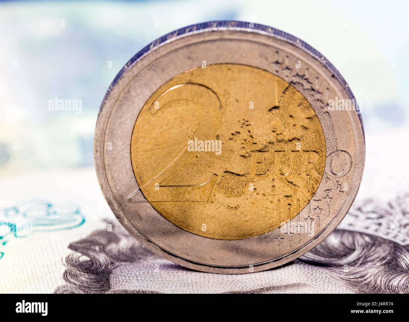 Two euros coin on british pound banknote Stock Photo - Alamy