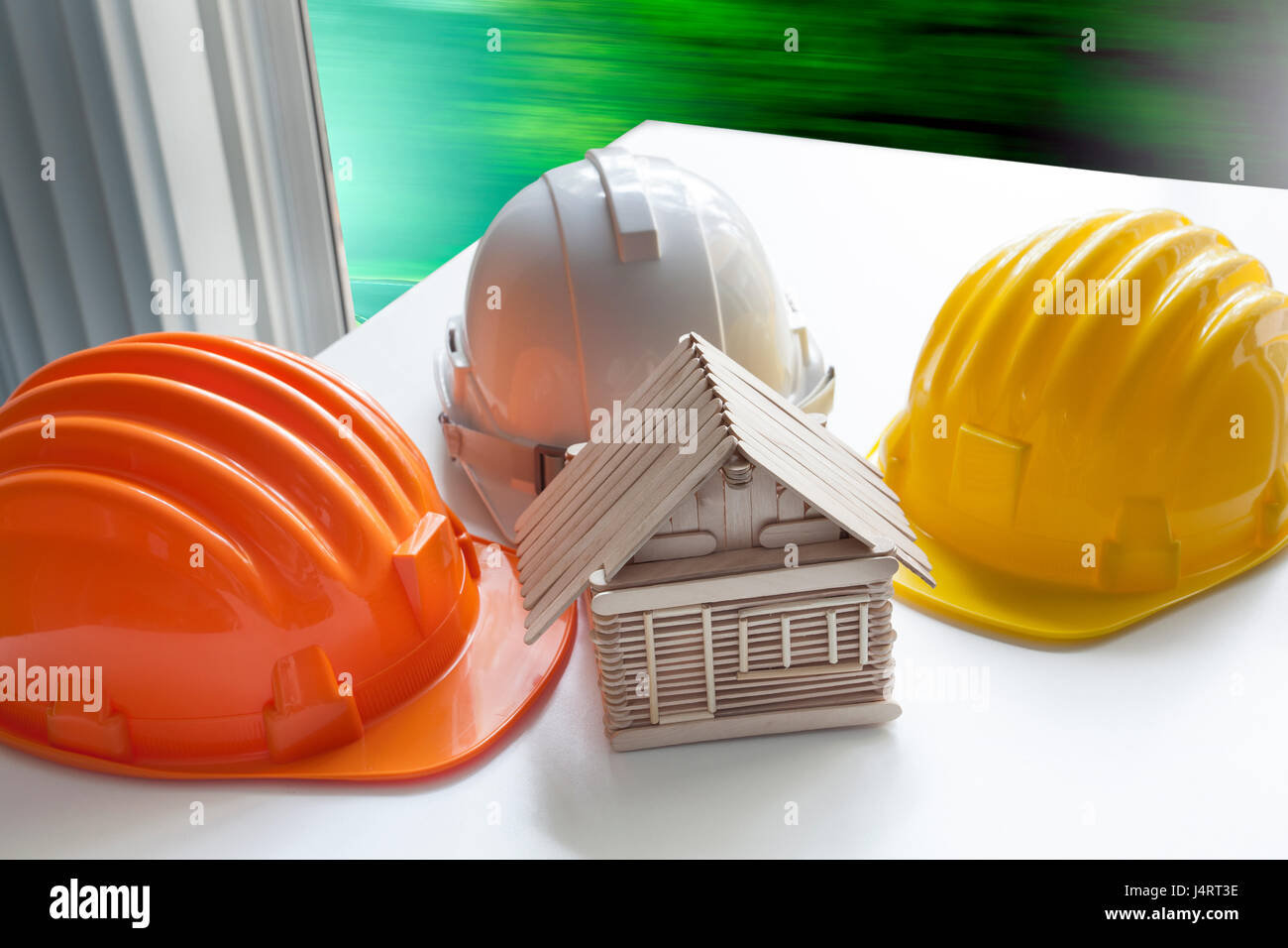 model of wood house on architect working table and safety helmet use ...