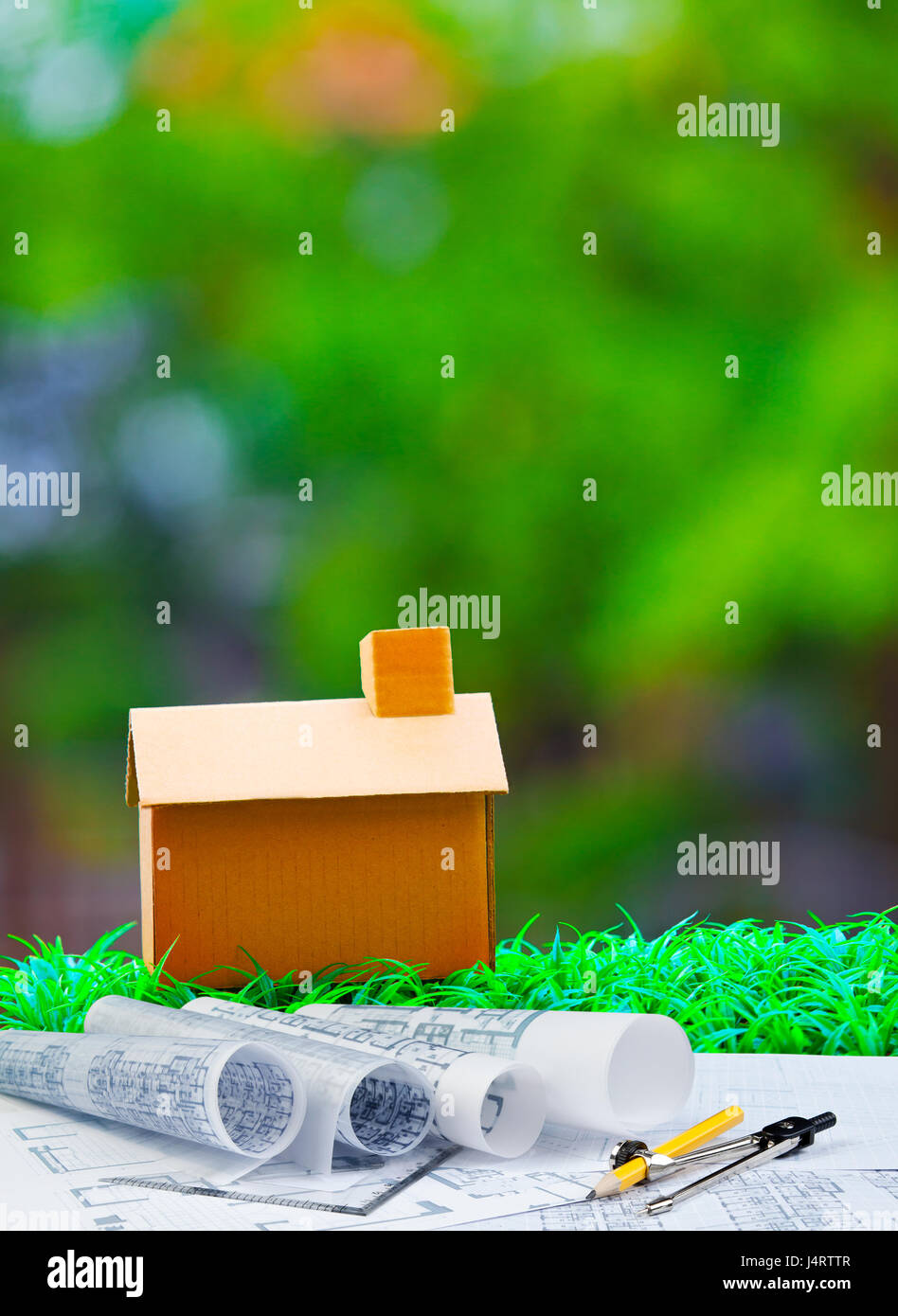 plan compass and paper work with home on green grass with blur ...