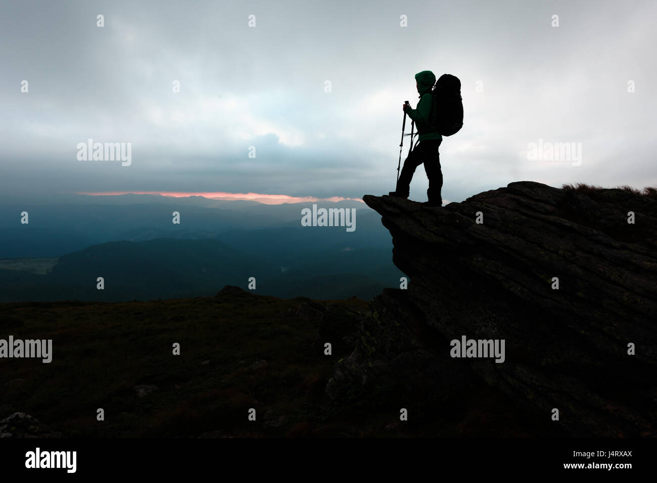 A lone tourist staying on the edge of the cliff against the backdrop of ...