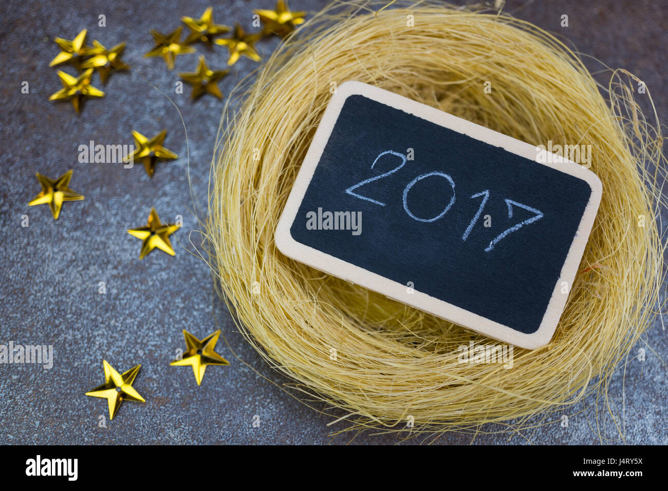 Happy new year greeting on chalkboard with golden stars on rustic tile ...