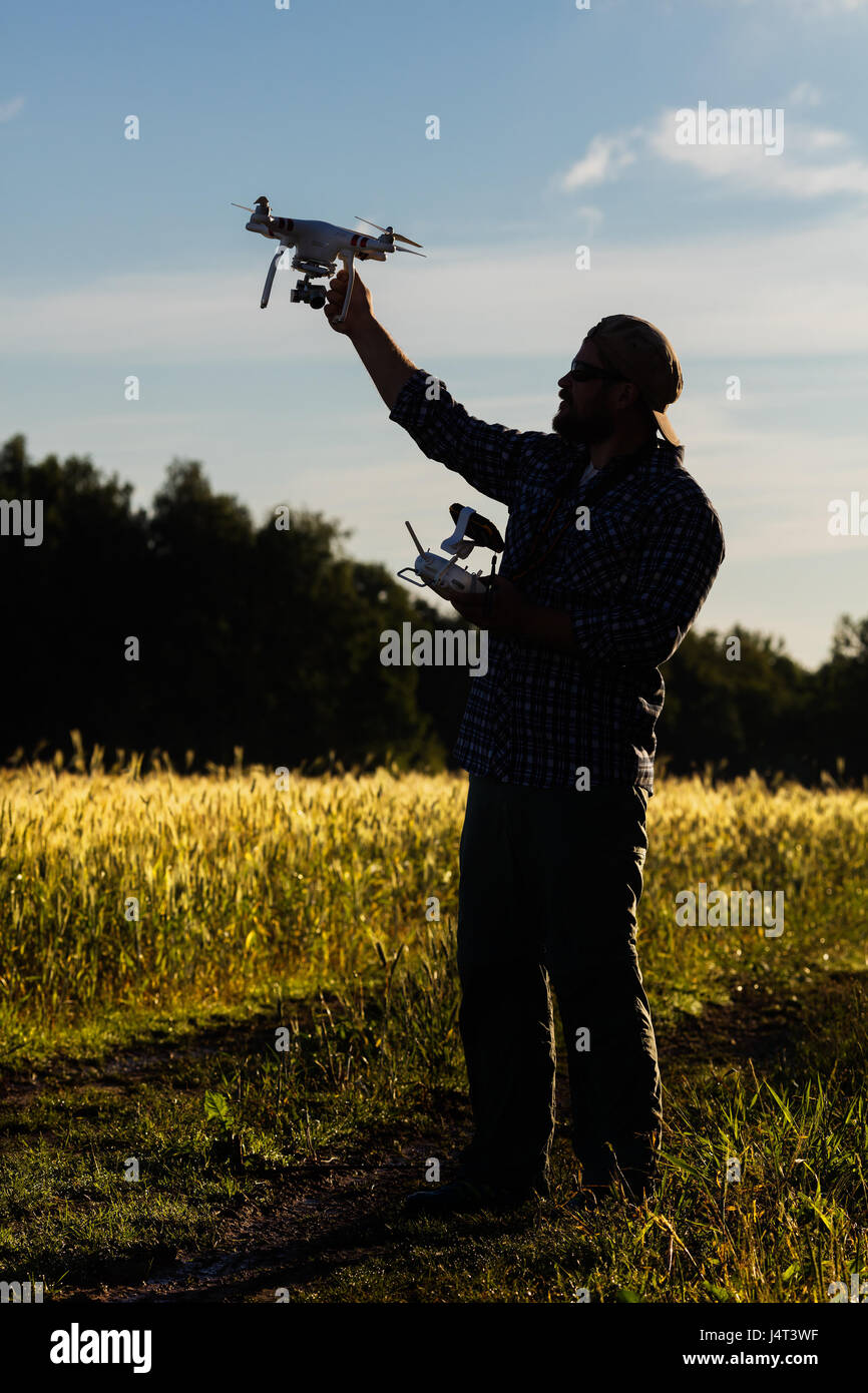 Operator holding drone and controller in his arms on natural background ...
