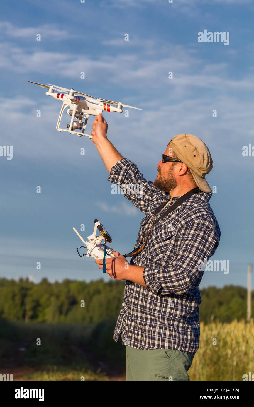 Operator holding drone and controller in his arms on natural background ...
