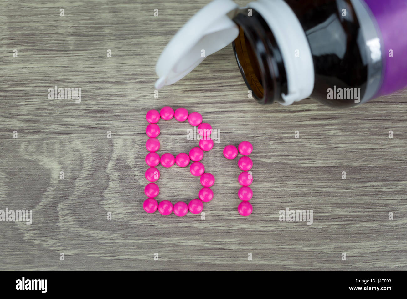 Pink pills forming shape to B1 alphabet on wood background Stock Photo ...
