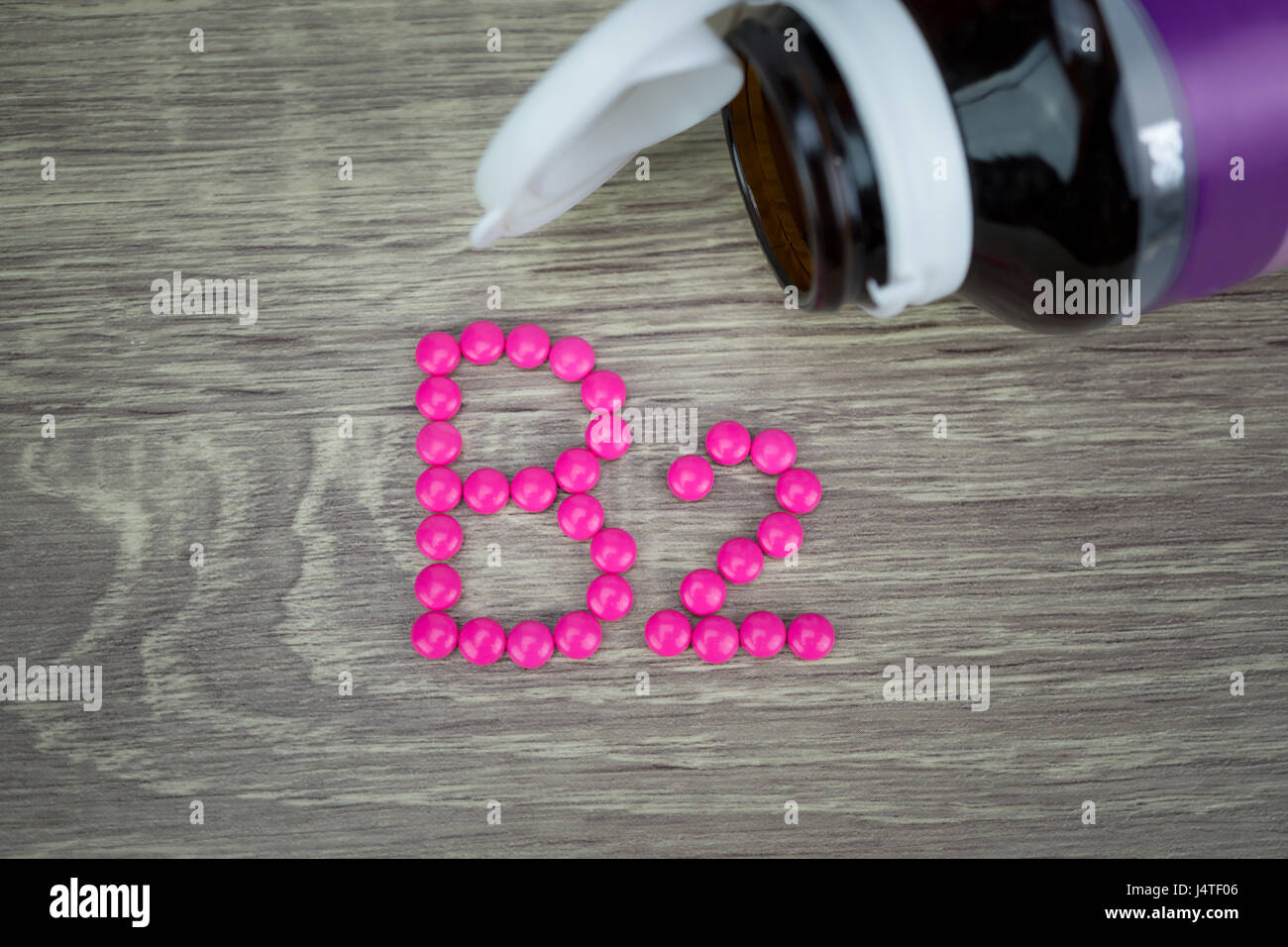 Pink pills forming shape to B2 alphabet on wood background Stock Photo ...