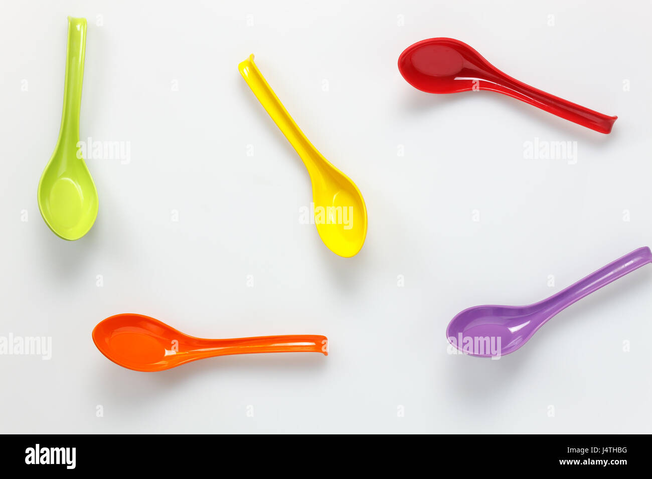 Top view colorful plastic spoon on white table background with copy ...