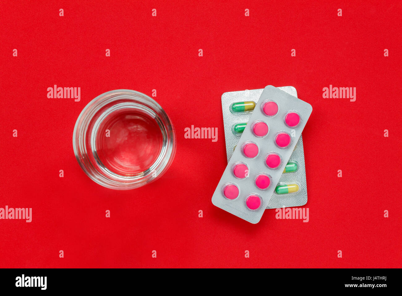 Top view colorful medicine and water on red background.Take a medicine ...