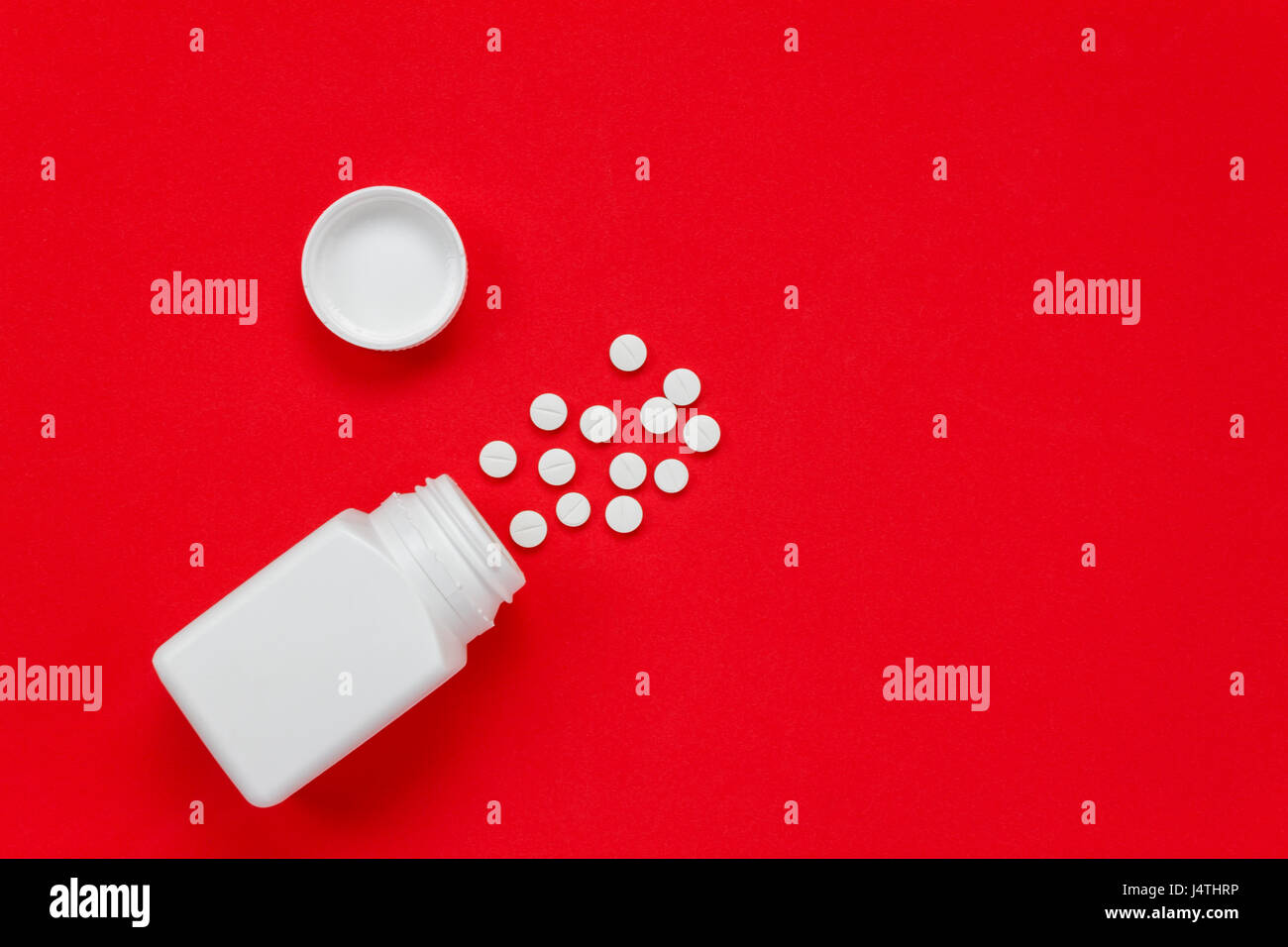 Top view pills pouring of pill bottle on red background.Take a medicine ...
