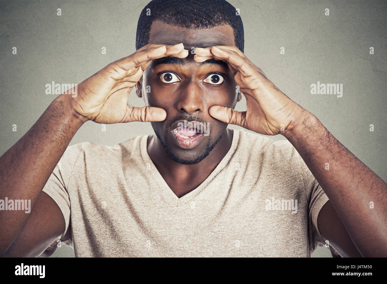 Portrait shocked young man isolated on gray wall background Stock Photo ...