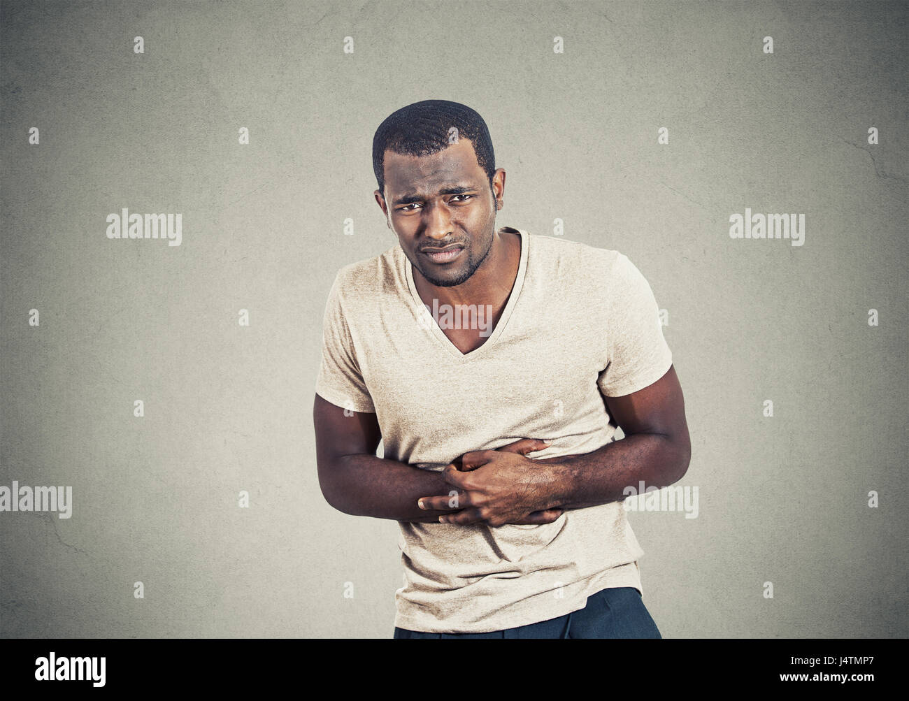 Unhealthy man, doubling over in stomach pain looking sick unwell ...