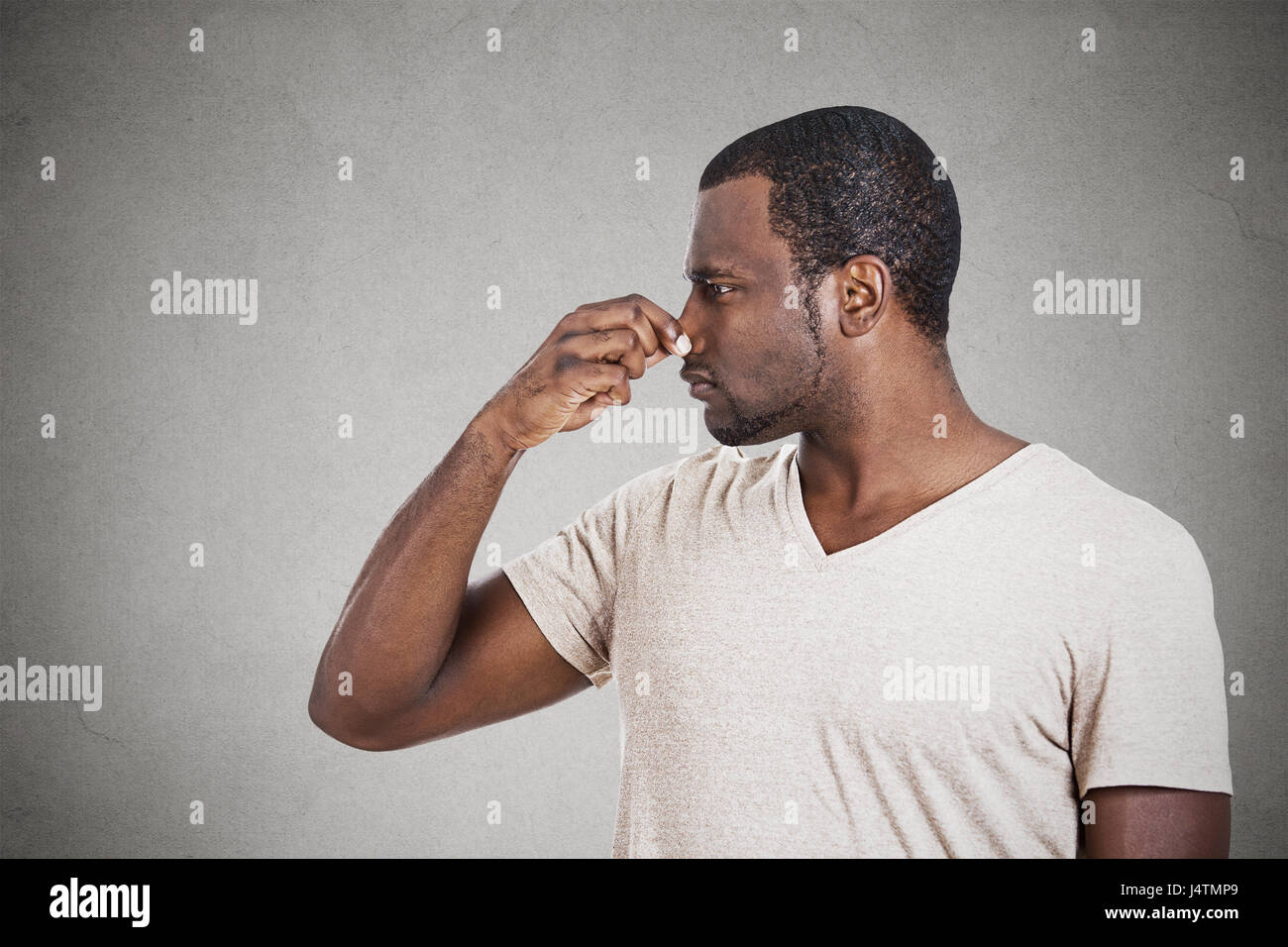 Closeup side profile portrait of man with disgust on face pinches his ...