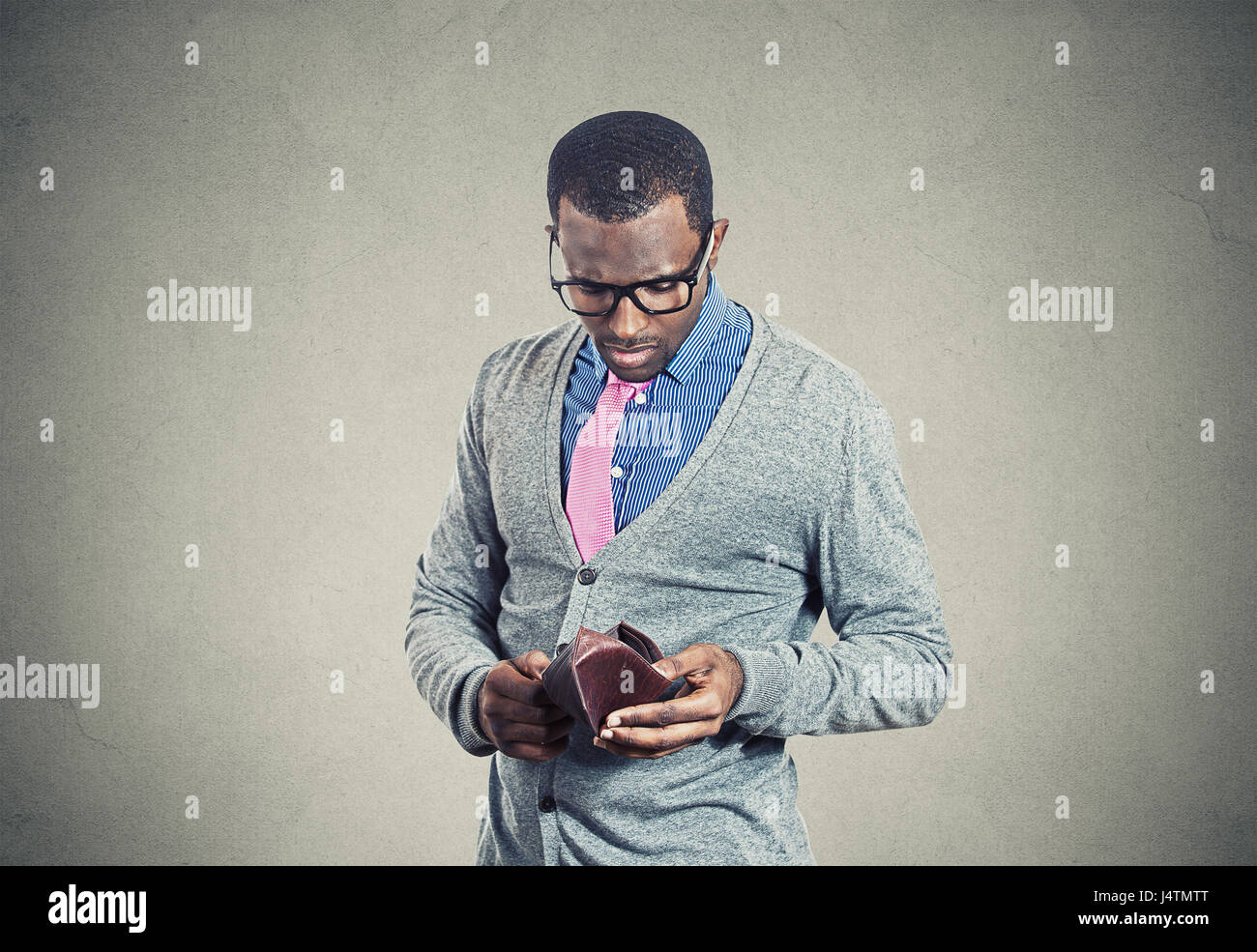 Young man looking into his empty wallet has no money Stock Photo - Alamy
