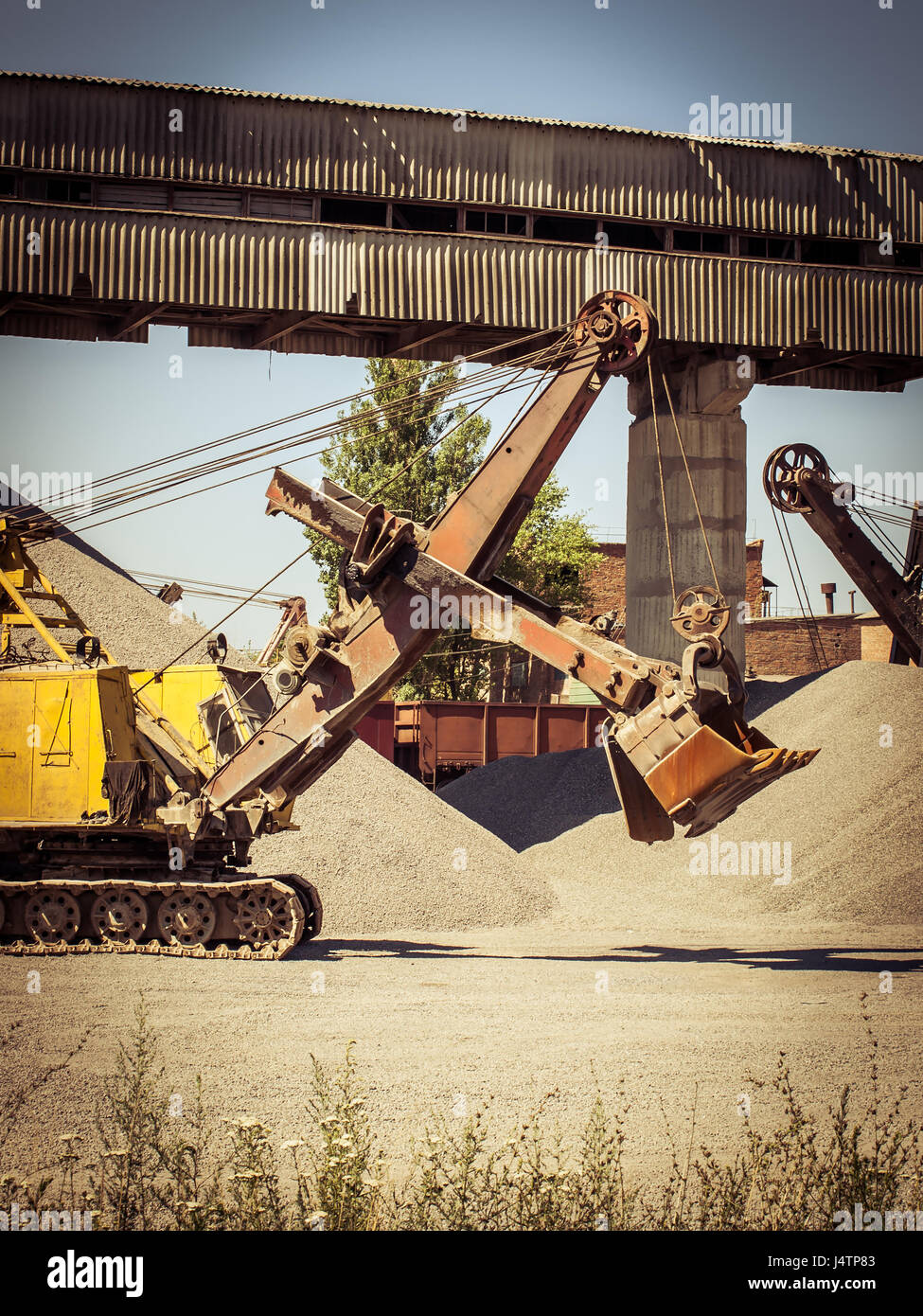 Old excavators loading the railway cars with stone on the stone quarry ...