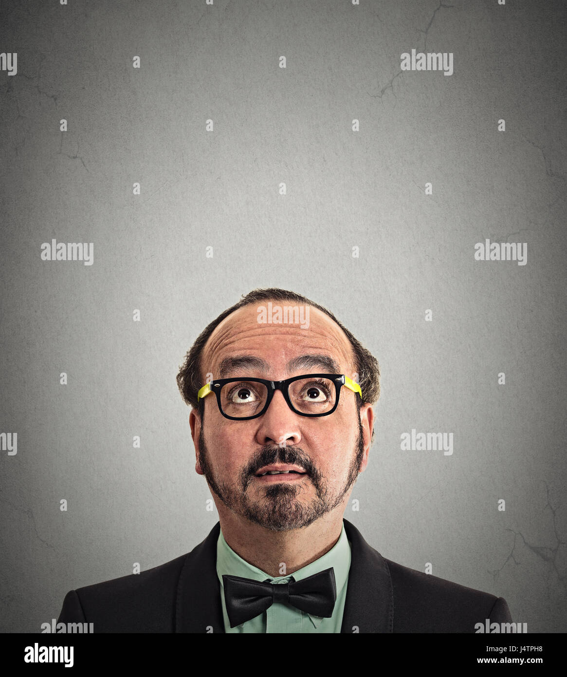 closeup portrait headshot middle aged man looking up isolated on grey ...