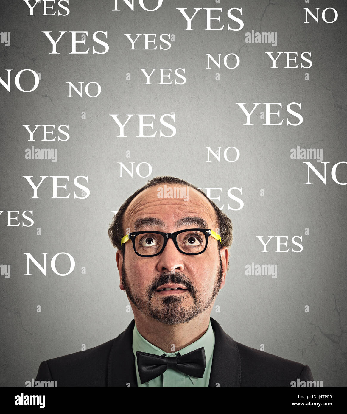 portrait headshot undecided business man looking up grey wall ...