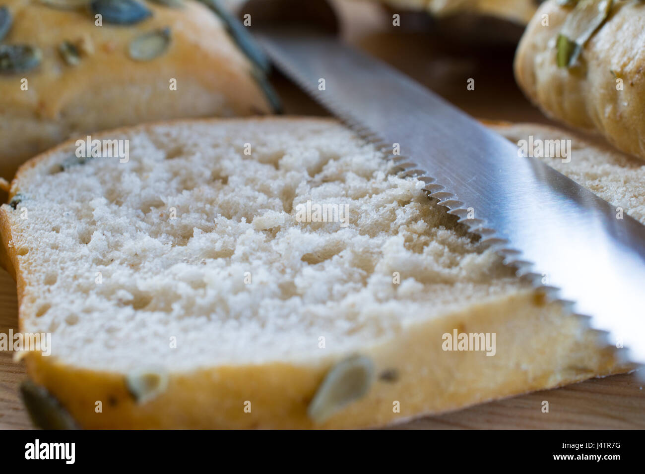 Sliced bun and knife blade closeup.. Shallow depth of field Stock Photo ...