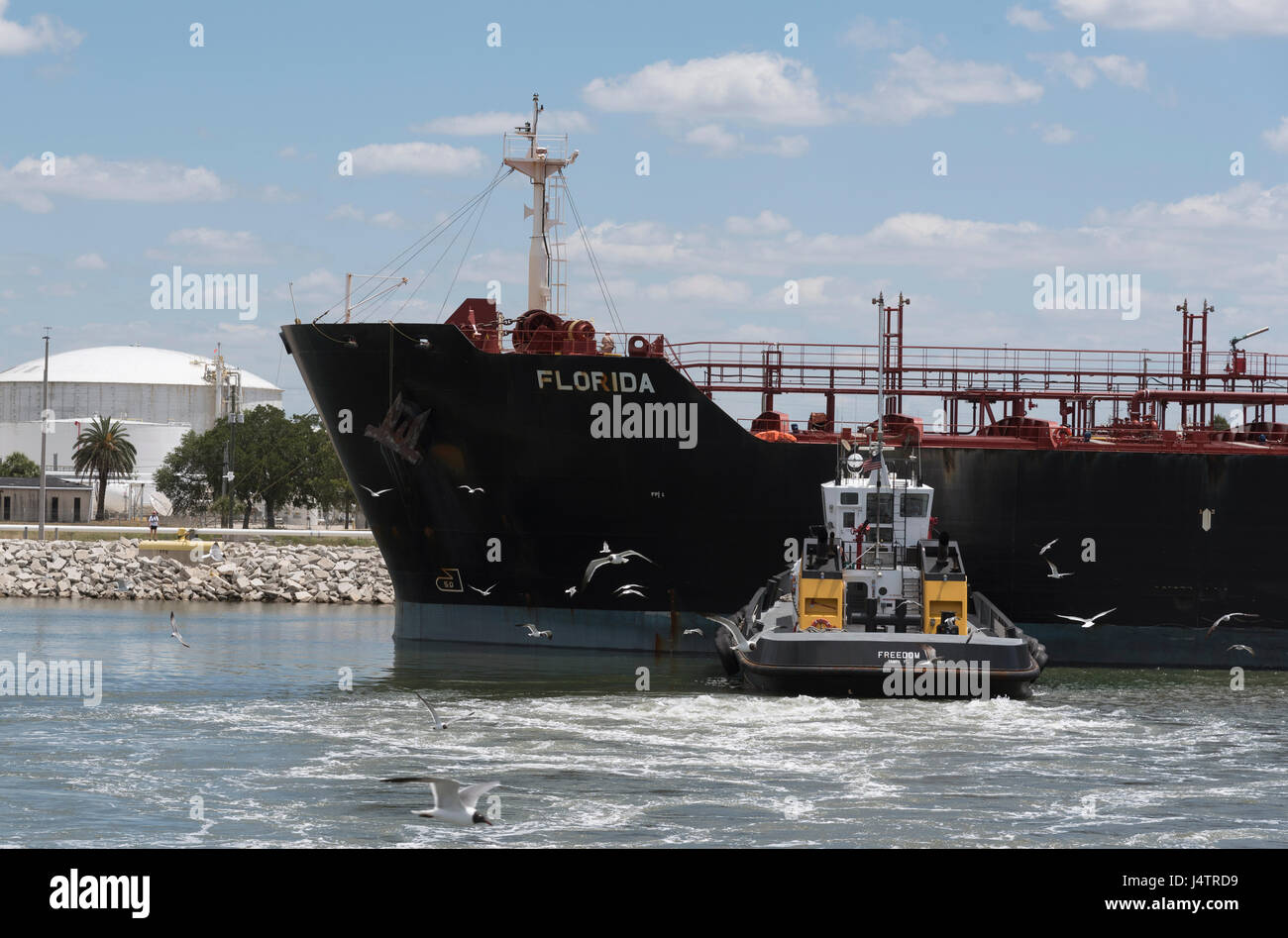 Tug pushing the hull of the Florida to position the tanker ship against ...
