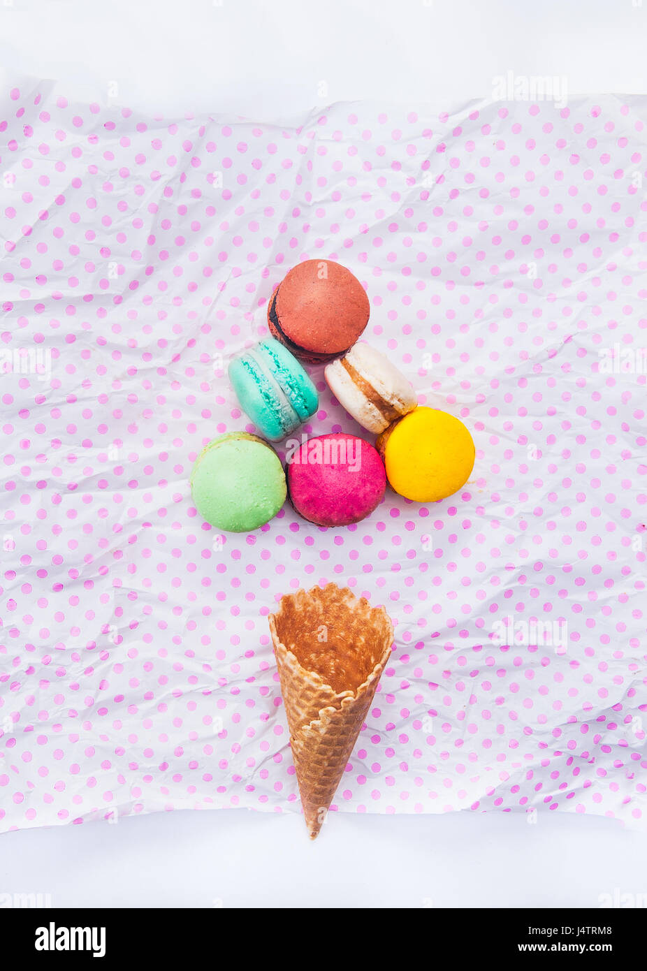 Multicolored cake macarons or macaroons in the triangle form and waffle ...