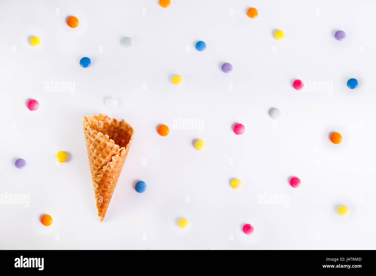 White Background with colorful candies and empty ice cream cone. Top ...