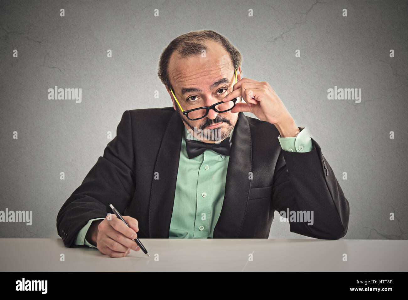 Serious businessman with glasses skeptically looking at you sitting at ...
