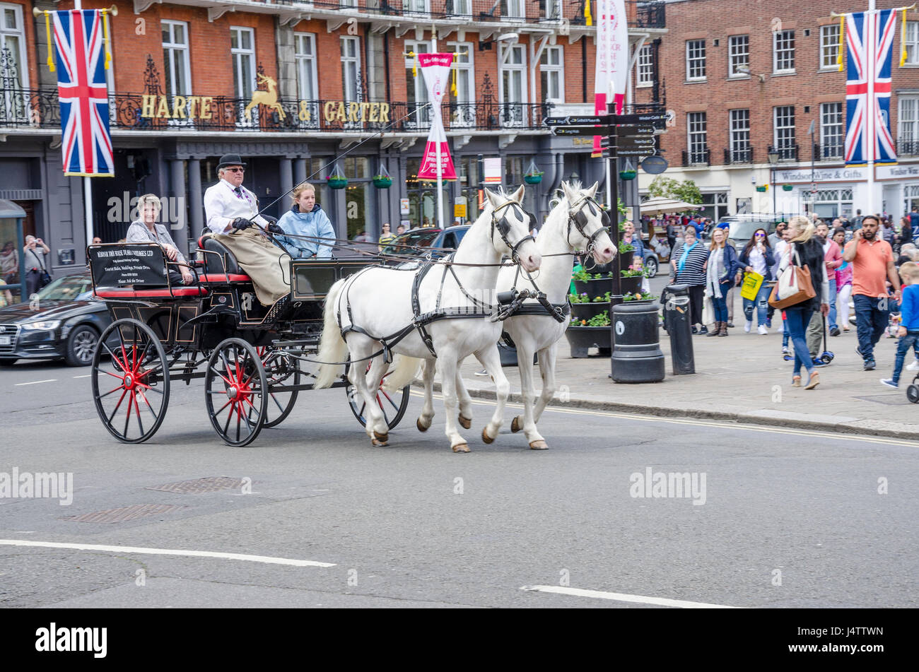 A horse drawn carriage rides past windsir Castle nthe UK Stock Photo ...