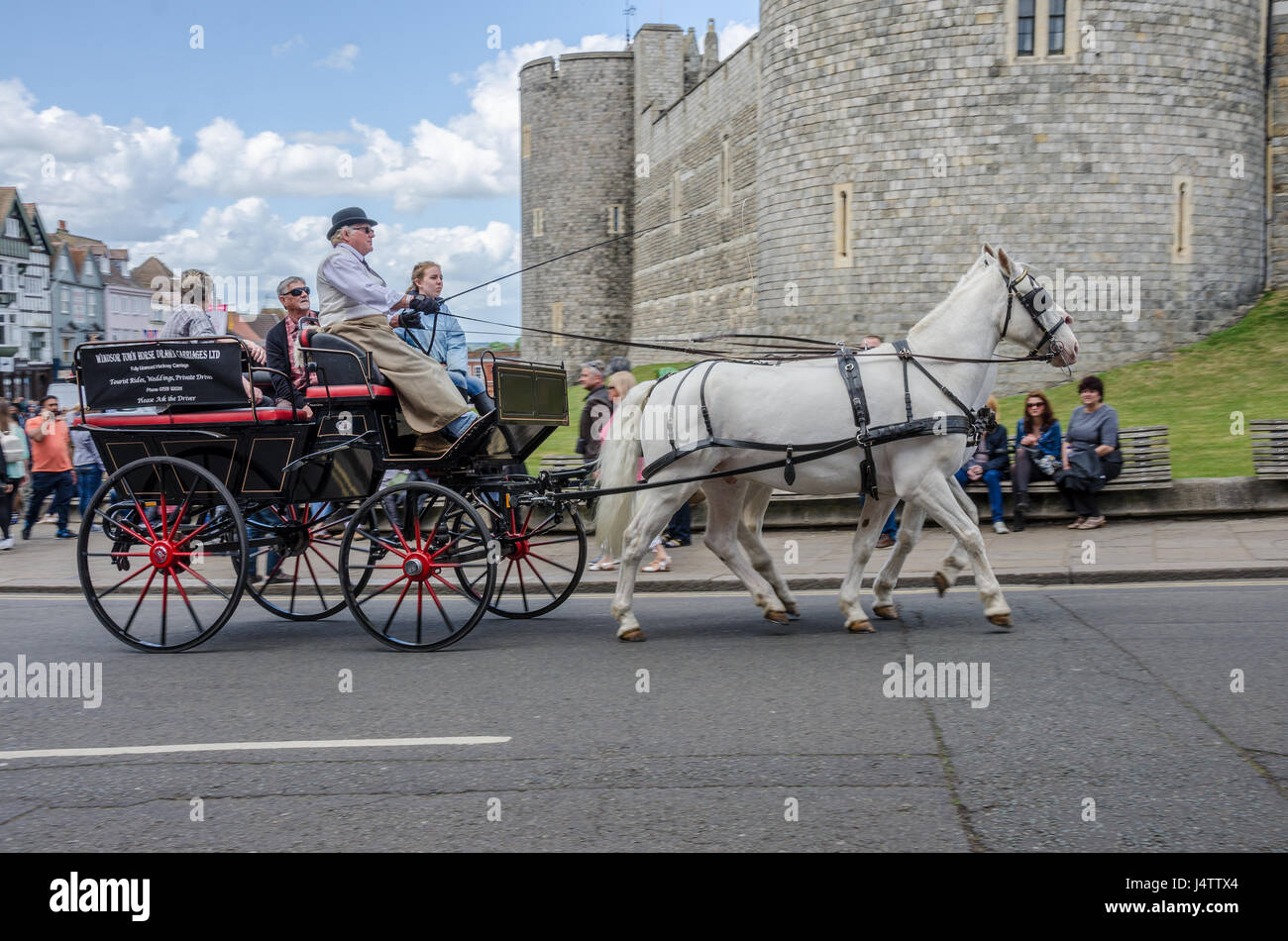 A horse drawn carriage rides past windsir Castle nthe UK Stock Photo ...