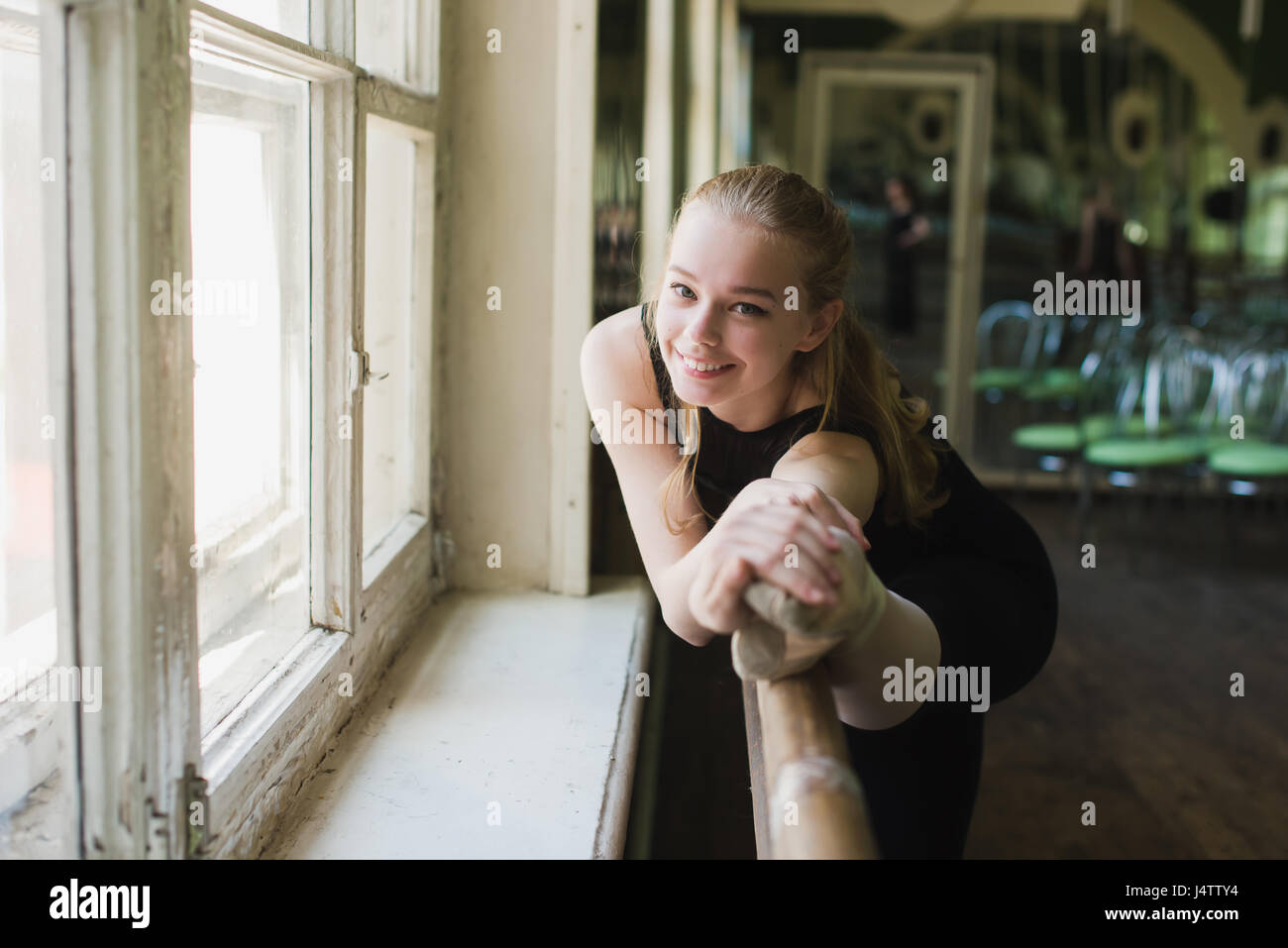 Young beautiful ballerina dancer warming up in ballet class. Girl ...