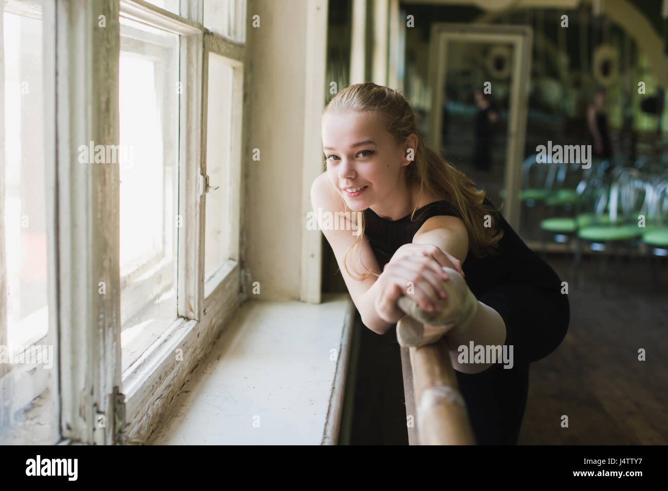 Young beautiful ballerina dancer warming up in ballet class. Girl ...