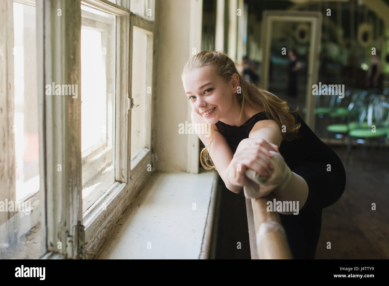 Young beautiful ballerina dancer warming up in ballet class. Girl ...