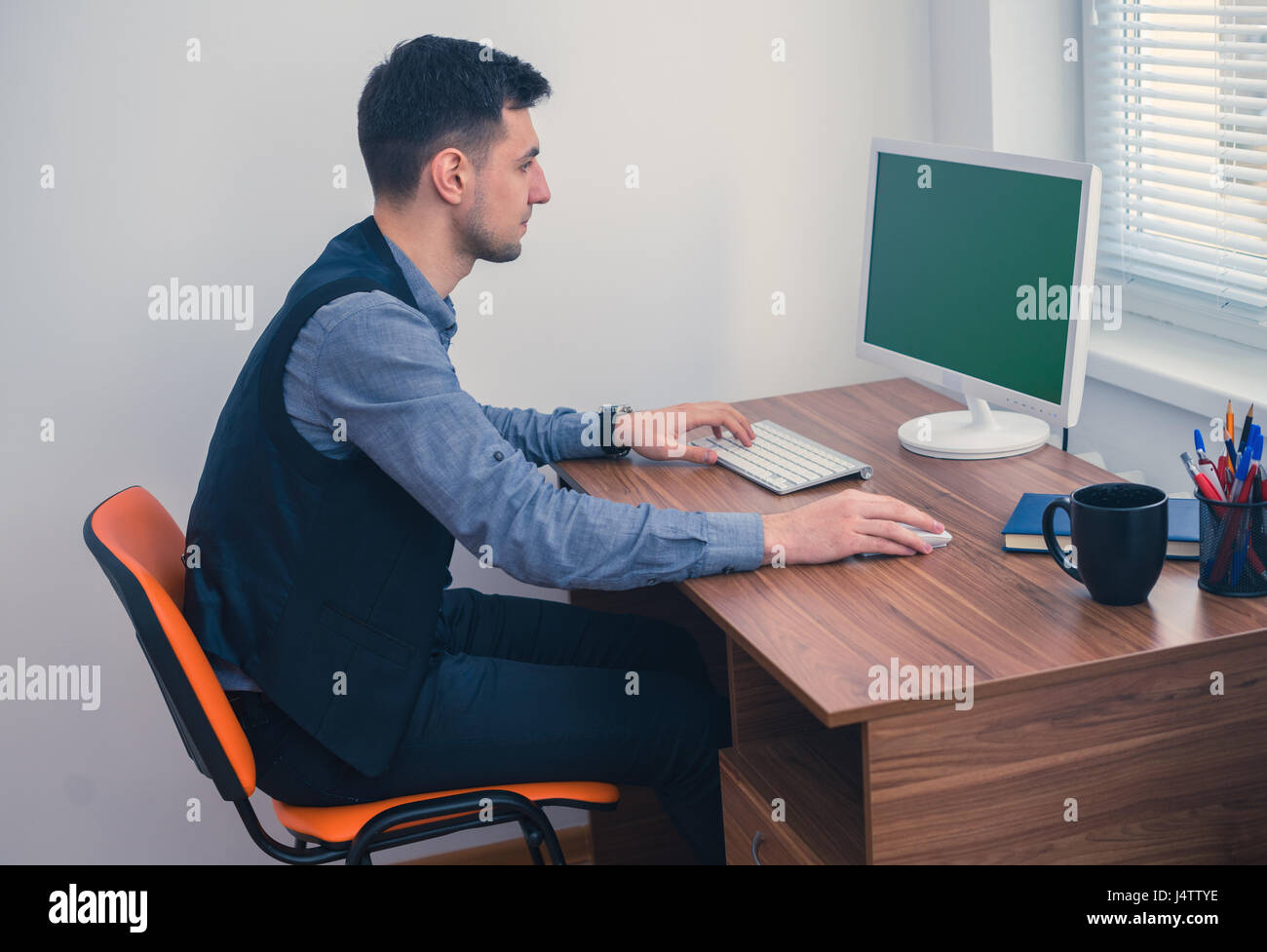office worker sitting at computer with Chromakey on monitor Stock Photo ...
