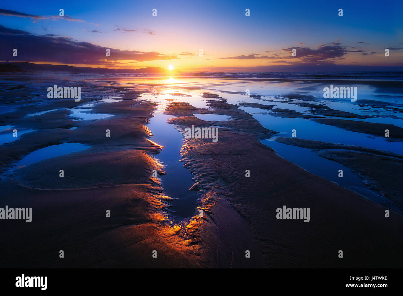 low tide in the beach with puddles at sunset Stock Photo - Alamy