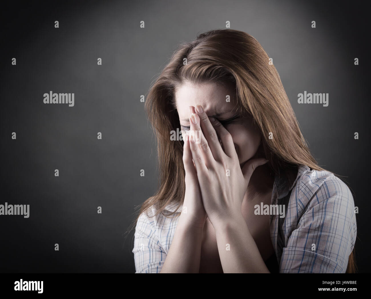 Crying woman on a dark background Stock Photo - Alamy