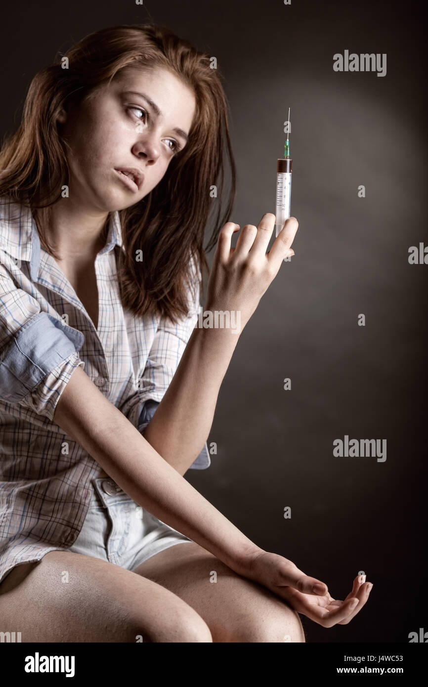Young woman with drug addiction on dark background Stock Photo - Alamy