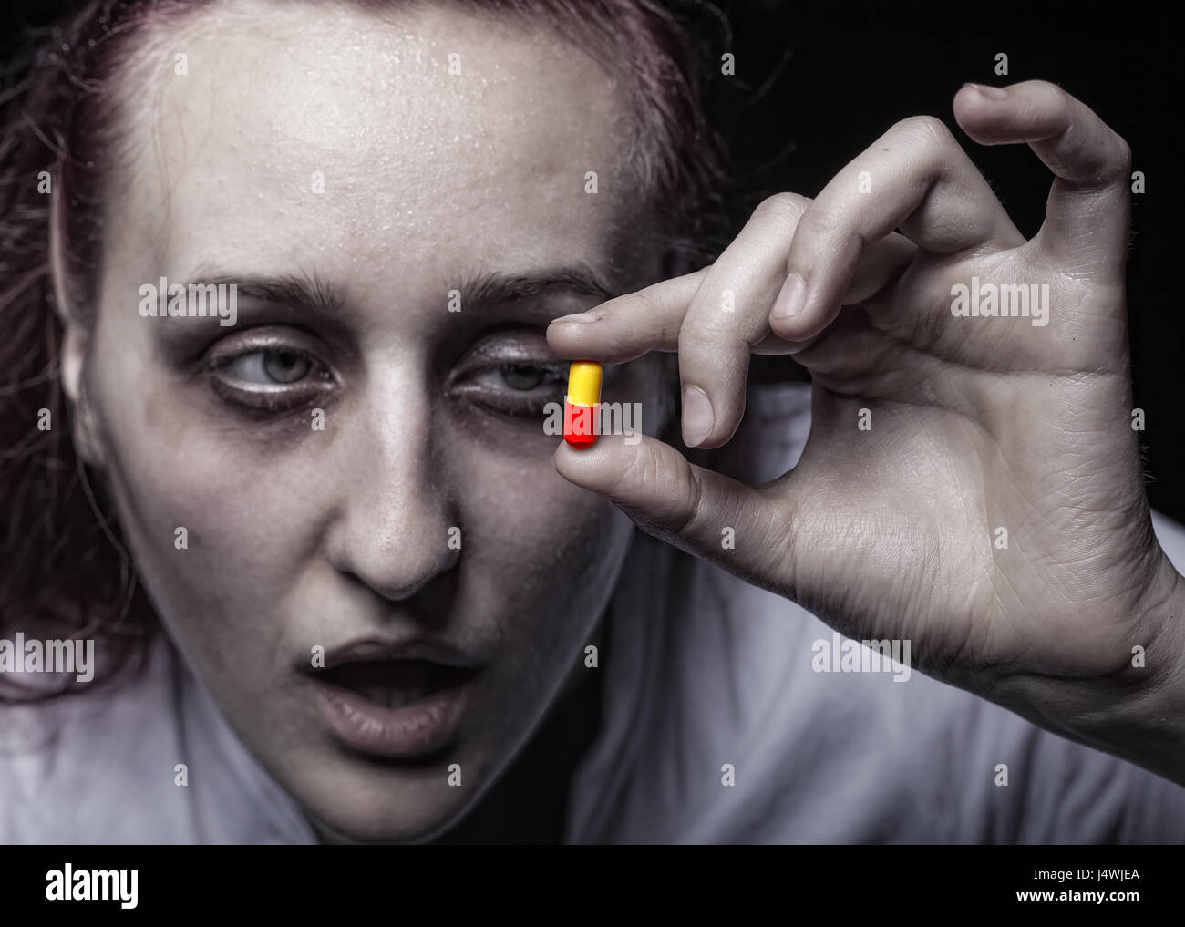 Young woman holding a pill addict. Focus on hands Stock Photo - Alamy