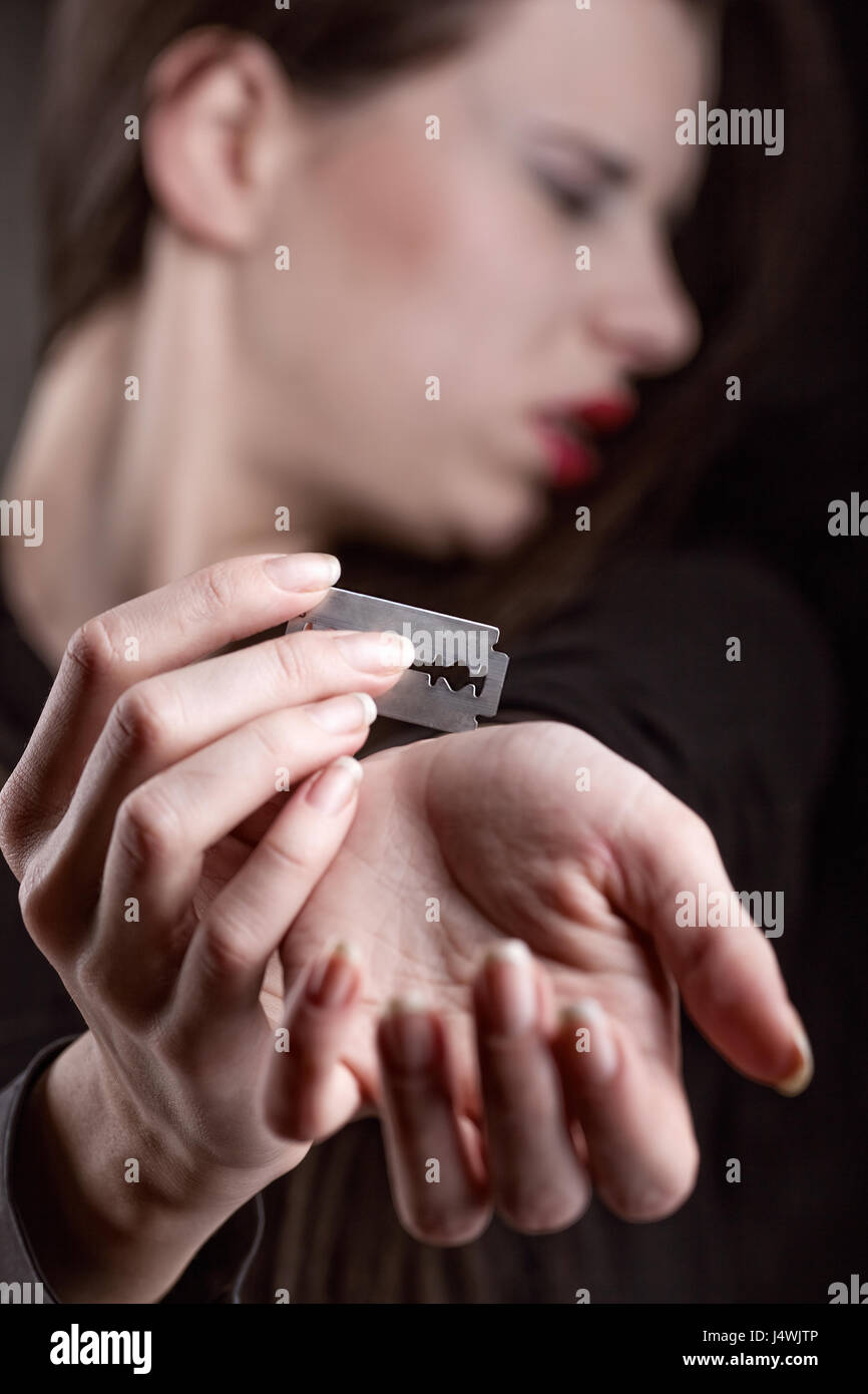 Young woman cuts veins on a hand. Focus on hand Stock Photo - Alamy