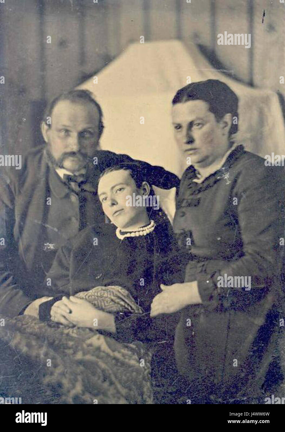 A Victorian-era post-mortem family portrait, depicting a somber scene ...