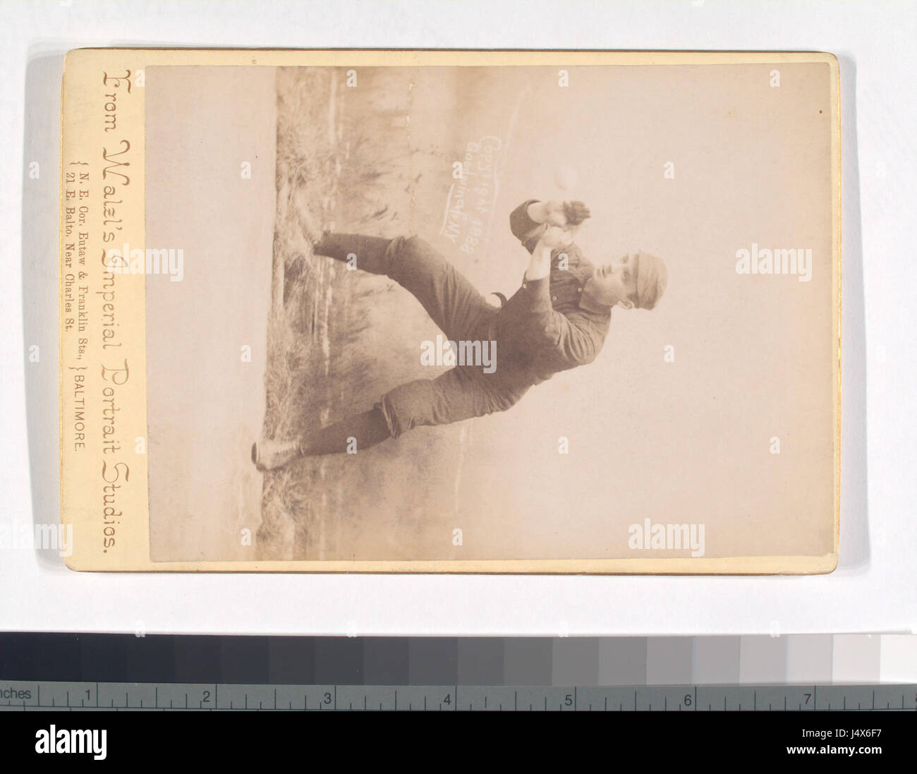 This image captures an unidentified baseball player in a dark uniform ...