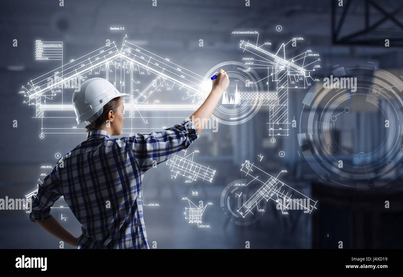 Builder woman standing with back and drawing blueprints Stock Photo - Alamy