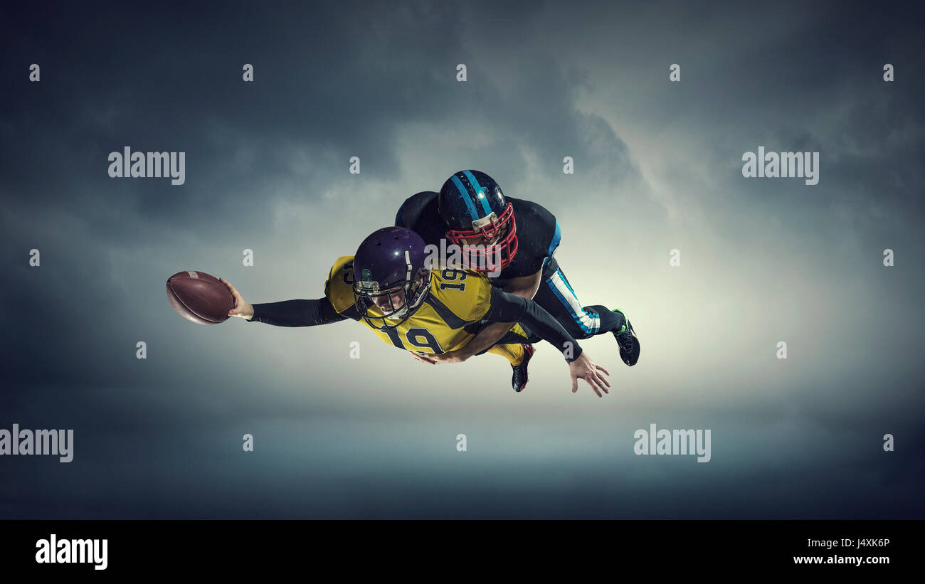 Two american football players fighting for ball Stock Photo - Alamy