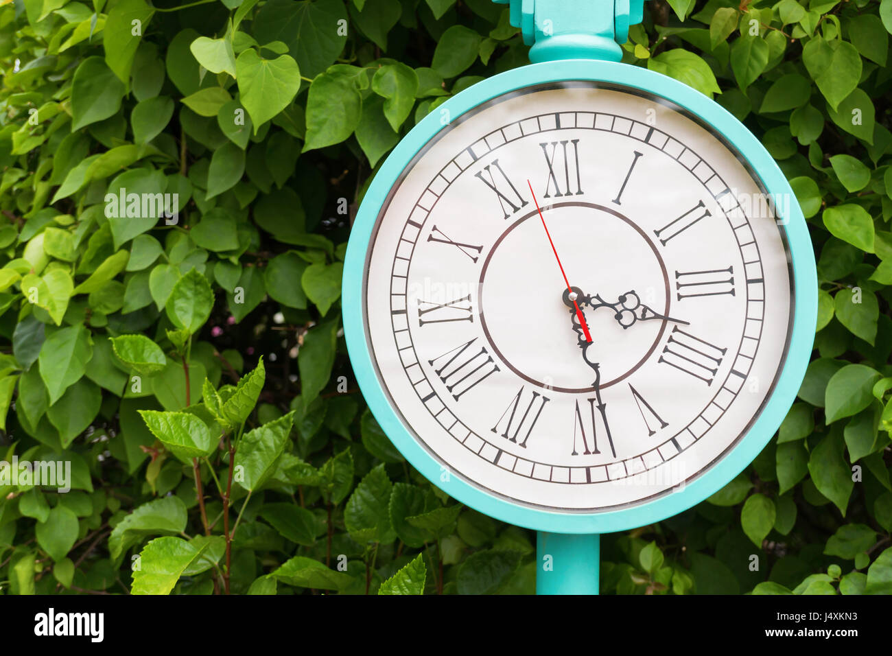 Antique turquoise color clock in the garden Stock Photo - Alamy