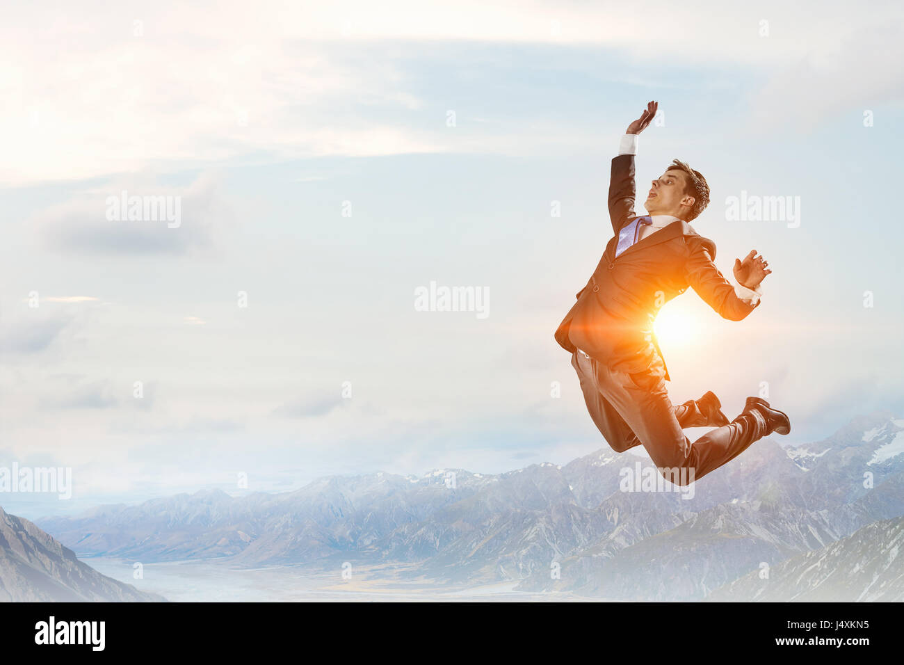 Happy businessman jumping high in sky to celebrate success Stock Photo ...