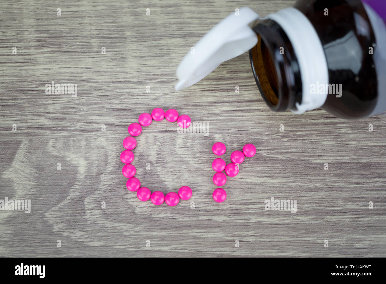 Pink pills forming shape to Cr alphabet on wood background Stock Photo ...