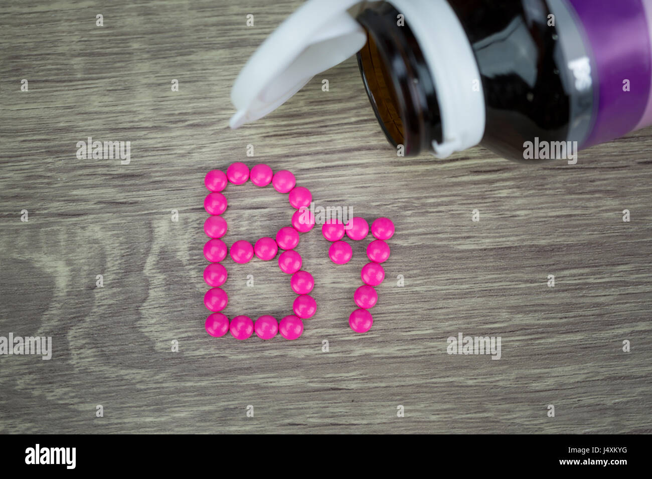 Pink pills forming shape to B7 alphabet on wood background Stock Photo ...