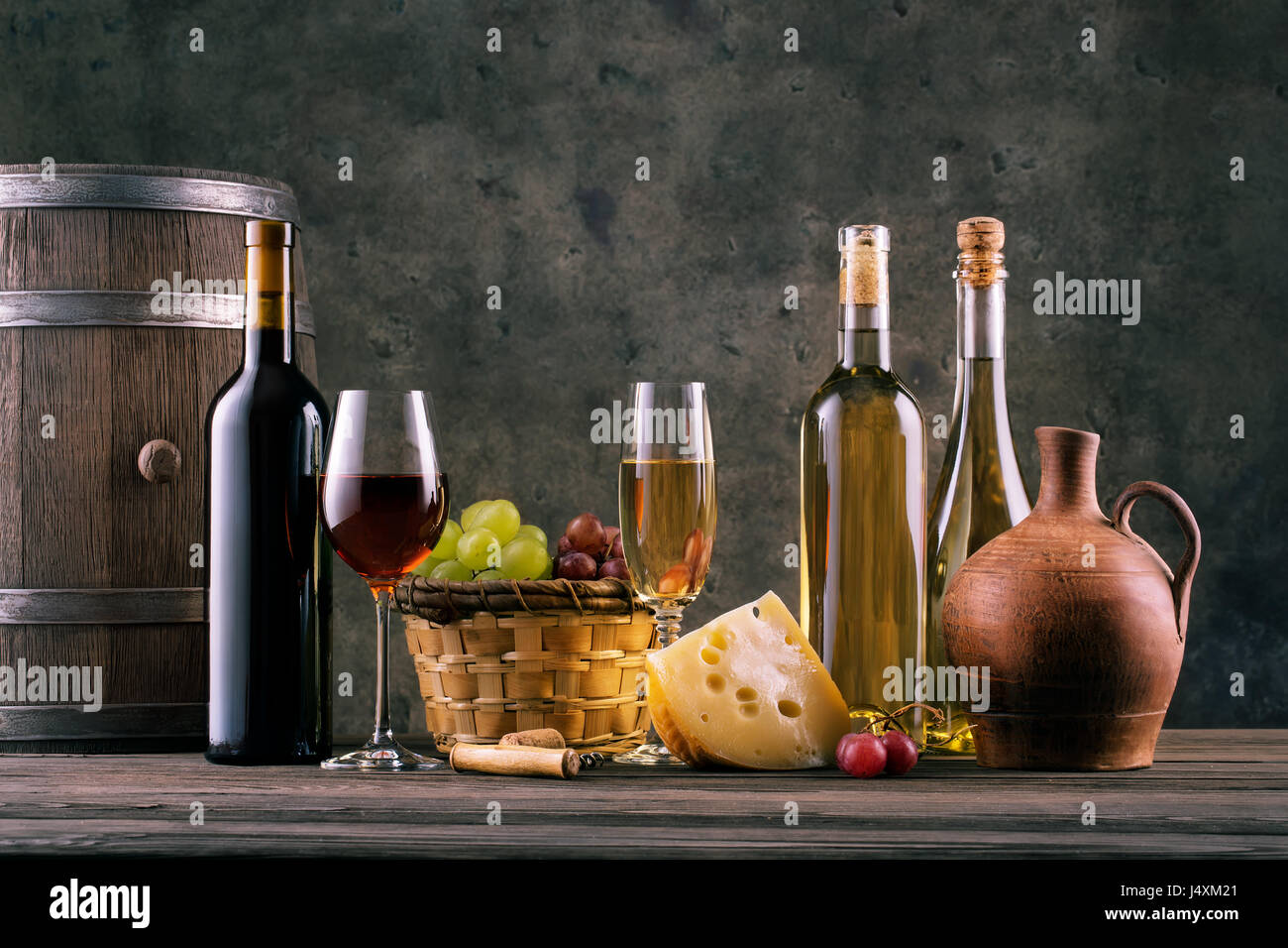 Wine still life with glasses of bottles and grapes against the dark ...
