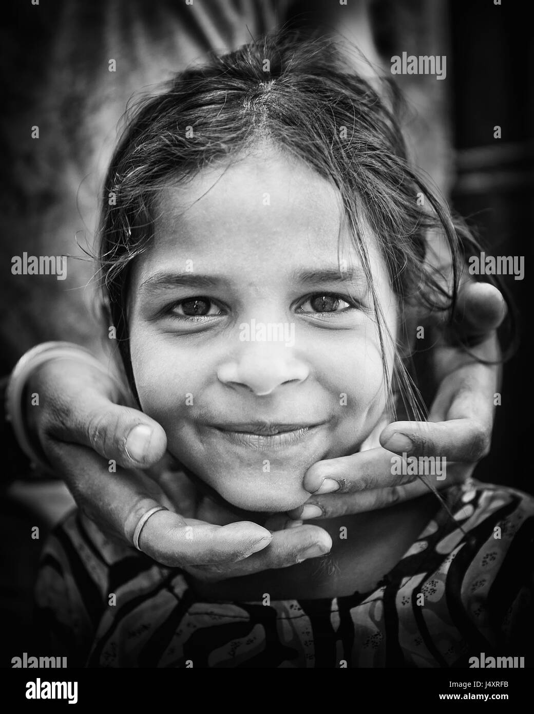 In New Delhi India, a father's worn hands tenderly and lovingly cradle ...